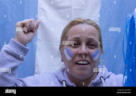Blonde Woman With A Flag And Face Painted In The Colors Of Argentina