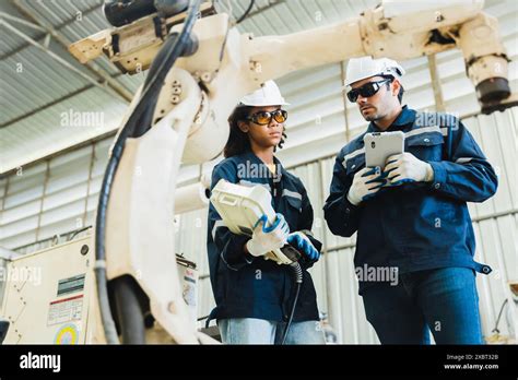 Engineer Controlling Robot Arm At Factory Checking The Operation Of Robot Arm Technology