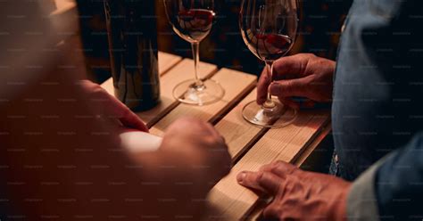 적포도주 잔을 들고 나무 상자 근처에 서 있는 인식할 수 없는 남자의 자른 사진 사진 Unsplash의 병 이미지