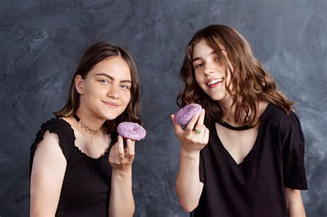 도넛의 자에 Siting와 재미와 아주 행복 한 십 대 소녀 검은 배경에 도너츠와 즐거운 웃는 여자의 초상화 좋은 분위기 다이어트 개념 2명에 대한 스톡 사진 및 기타