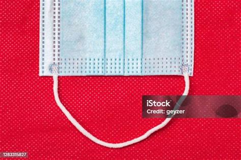 부직포 밝은 붉은 색의 배경에 파란색 의료 얼굴 마스크의 조각 개념 글로벌 문제 잠금 코로나바이러스 전염병 19 질병 0명에 대한 스톡 사진 및 기타 이미지 Istock