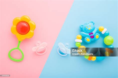 아기 소녀를위한 꽃 딸랑이와 밝은 분홍색 파란색 테이블 배경에 아기 소년과 Soothers에 대한 공과 곰 파스텔 색상 근접 촬영 하향 보기 쌍방 딸랑이에 대한 스톡 사진