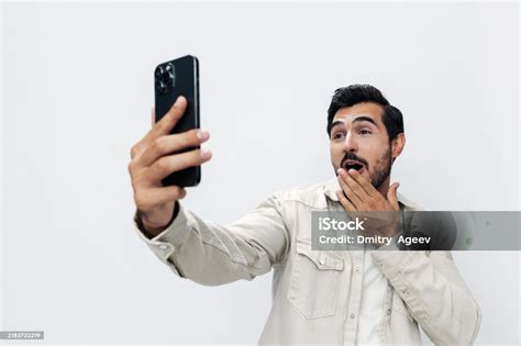 손에 휴대 전화를 들고 클로즈업 된 초상화 남자는 셀카 블로거가 흰색 고립 된 배경 세련된 의류 스타일 복사 공간 텍스트 공간에 놀라움을 표합니다 25 29세에 대한 스톡