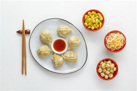 젓가락 절인 버섯 고추 쌀국수와 함께 흰색 테이블에 소스를 얹은 접시에 다진 고기와 함께 삶은 만두 사만티 또는 원톤 수제 음식 위에서 보기 닭고기에 대한 스톡 사진 및