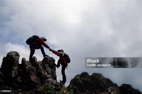 높은 산에서 장엄한 산의 경치를 보는 젊은 관광객 커플 맨 위 바위에 남자와 여자 등산객 사랑에 빠진 두 명의 여행자 사람들은 새벽을 맞이합니다 연인들은 여행합니다 공간