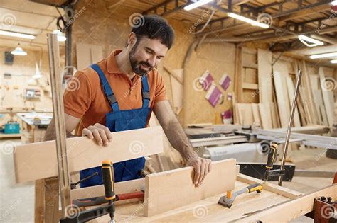 Male Artisan Worker Holding And Assembling Pieces Of Wood Using Glue