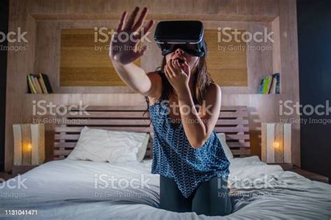 젊은 매력적인 흥분 하 고 행복 한 여자 Vr 가상 현실 게임 헤드셋을 착용 즐기는 재생 디지털 3d 경험을 보고 하 고 침대에 환상을 감동 3차원 형태에 대한 스톡 사진