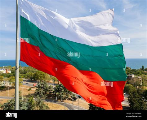 The Bulgarian Flag Waves Proudly Above A Coastal City With The Vast