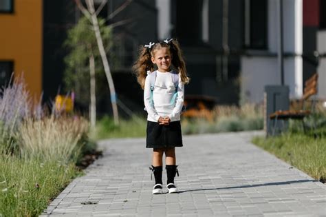 Ein kleines Mädchen geht durch den Park am Weg zur Schule. Fernunterrichtskonzept. Schülerin ...