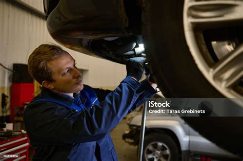 램프를 사용하여 섀시를 확인하는 자동차의 정렬을 확인하는 정비사 정비 서비스 센터에서 타이어를 점검하는 자동차 엔지니어 고객을 위한 기술자 또는 엔지니어 전문 업무 차에