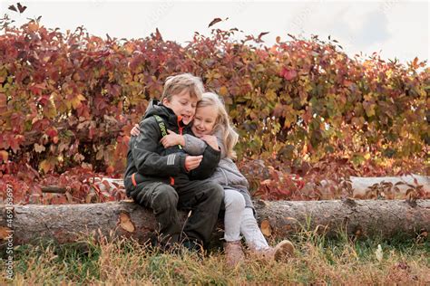 Loving Siblings Brother And Sister Having Fun In Park With Dry Yellow