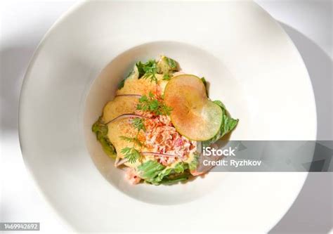 거친 그림자가있는 흰색 테이블에 게 고기 에스푸마 소스 및 양상추를 곁들인 우아한 샐러드 여름 메뉴에 게와 크림 소스를 곁들인 그린 샐러드 미적 음식 해산물 전채 갈고리