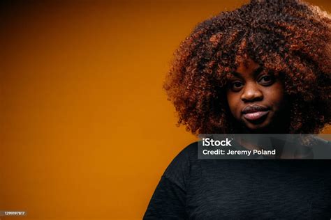 자신감 아름답고 진지한 얼굴 젊은 아프리카 계 미국인 여성의 스튜디오 초상화는 노란색 겨자 색 배경과 복사 공간이있는 극적인 조명 앞에서 카메라를 보고 있습니다 18 19