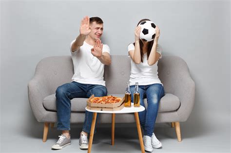 커플 여자 남자 축구 팬 응원이 회색 배경에 고립 된 정지 제스처를 보여주는 축구공으로 얼굴을 덮고 좋아하는 팀 지원 사람들의 감정 스포츠 가족 레저 라이프 스타일