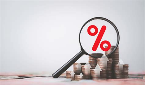 동전 쌓기 상단의 돋보기 내부의 빨간색 백분율과 금융 은행의 위쪽 화살표는 비즈니스 성장 개념에서 이자율 또는 모기지 투자 배당금을 증가시킵니다 정부에 대한 스톡 사진 및