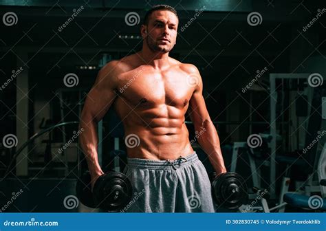 Training In Gym With Dumbbells Sportsman With Naked Torso Sporty Workout Athletic Body Stock
