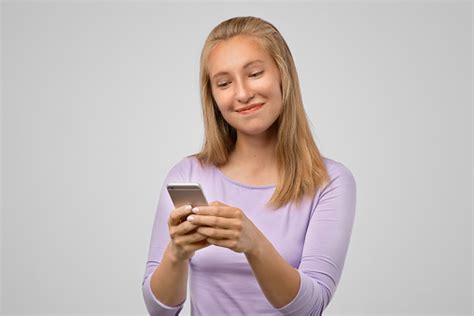 만족 식 사랑 여자 친구 문자 행복 메시지입니다 기쁘게 장난 어린 소녀 캐주얼 복장 스마트폰 들고와 광범위 하 게 만족 화면을 쳐다 보며 미소의 초상화 광고에 대한 스톡