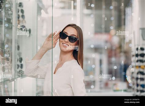 Close Up Of Gorgeous Young Woman Smiling Picking And Choosing Glasses