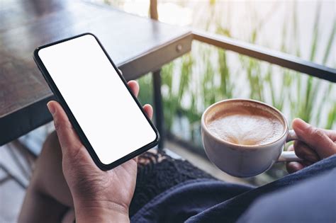 카페에서 커피를 마시는 동안 빈 화면이 검은 휴대 전화를 들고 여자의 이랑 이미지 커피 마실 것에 대한 스톡 사진 및 기타 이미지 커피 마실 것 휴대용 통신 기기