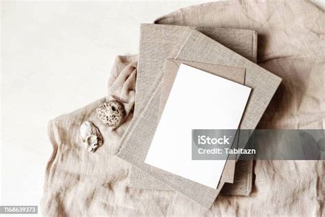 여성 문구 데스크톱 모형 장면 빈 인사말 카드 공예 봉투 바다 조개 및 베이지 색 린넨 식탁보 배경에 오래 된 책 플랫 레이