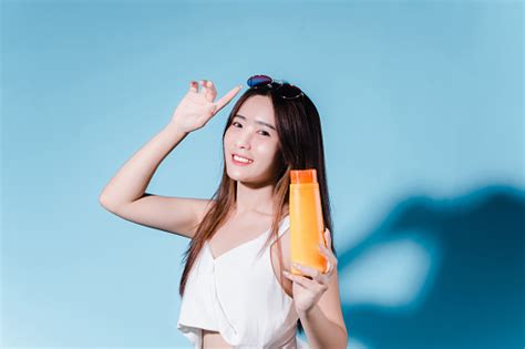 매력적인 아시아 뷰티 우먼은 파란색 배경에 자외선 차단 Uv 또는 자외선 차단제로 선크림과 컬러 스케일을 들고 있습니다 18