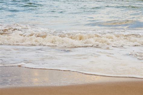 Sandy Beach On A Sunset With Reflection On Wet Sand And Waves With Foam