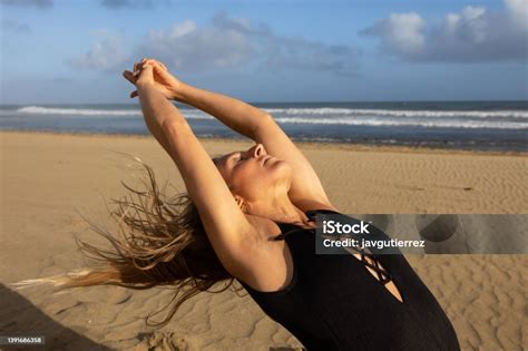Portrait Of Long Haired Woman Concentrating On Practicing Yoga On The