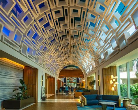 Tourists Meandering Through The Arched Corridor Lined With Cafes And