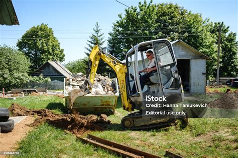 미니 굴삭기는 토양에 도랑을 파고 있습니다 굴삭기 운전자가 버킷을 제어합니다 크롤러 머신 토공 장비 굴착 건설 현장에서 굴착 작업 개발에 대한 스톡 사진 및 기타 이미지