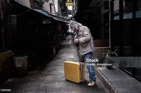 아시아의 빈곤한 노숙자는 좁은 골목에서 큰 여행 가방을 끌고 걷고 가난한 사람은 슬럼프에 살고 일자리가 없고 불쌍한 노인 문제는 금융 위기로 인해 가족이 없는 실업입니다