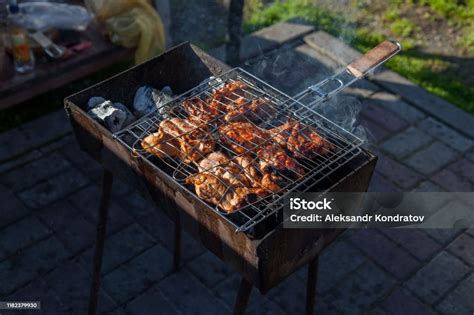 돼지 고기 또는 쇠고기 고기의 Shashlik 요리 과정에 클로즈업 연기가 올라가는 오픈 화재에 회색 탄 석탄 위에 바삭한 탄 껍질과 그릴에 고정 건강한 식생활에 대한 스톡