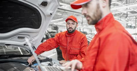 빨간색 유니폼을 입은 두 명의 자동차 정비사가 자동차 서비스에서 컴퓨터로 엔진 진단을 하고 있다 사진 Unsplash의 일하는 사람들 이미지