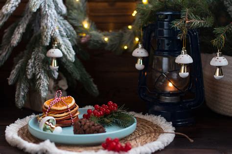 장난감이 있는 크리스마스 트리와 빨간 가막살 나무속 열매와 오렌지 조각이 담긴 접시 새해 조명 12월에 대한 스톡 사진 및 기타 이미지 Istock