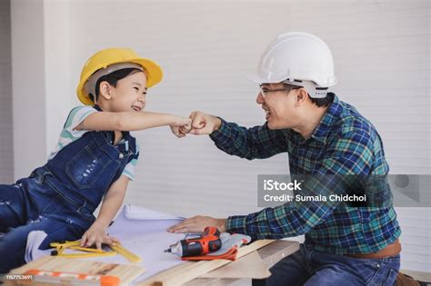 손에 벽돌을 가진 아버지와 어린 소년웃음 남자와 어린 소년은 집에서 건설 엔지니어로 재생 즐기고있다 가족과의 사랑과 관계