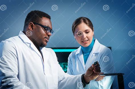 Group Of Microelectronic Engineers Discussing In A Modern Microprocessor Manufacture Lab