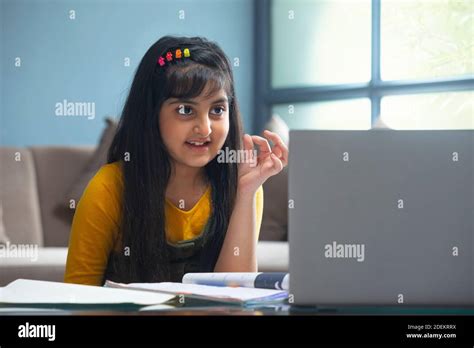 Young Girl Calculating Numbers On Her Fingertips In Front Of Her Laptop During Online Class