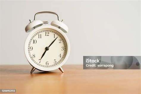 복사 공간 갈색 나무 책상과 크림 벽지 질감 배경에 흰색 알람 시계 0명에 대한 스톡 사진 및 기타 이미지 0명 가정 생활 가정의 방 Istock