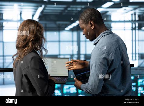 Programmers In Data Center Facility Workplace Use Laptop To Calibrate Supercomputers Energy