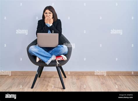Young Hispanic Woman Sitting On Chair Using Computer Laptop Laughing