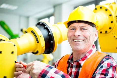 Premium Photo Portrait Of Smiling Technician Working On Industrial Robot