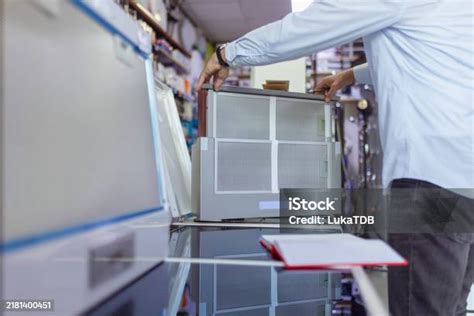 알아볼 수 없는 가전제품 매장의 주인이 주방 가전제품 스토브 오븐 및 후드가 있는 섹션에 서서 재고를 나열하고 있습니다 45 49세에 대한 스톡 사진 및 기타 이미지