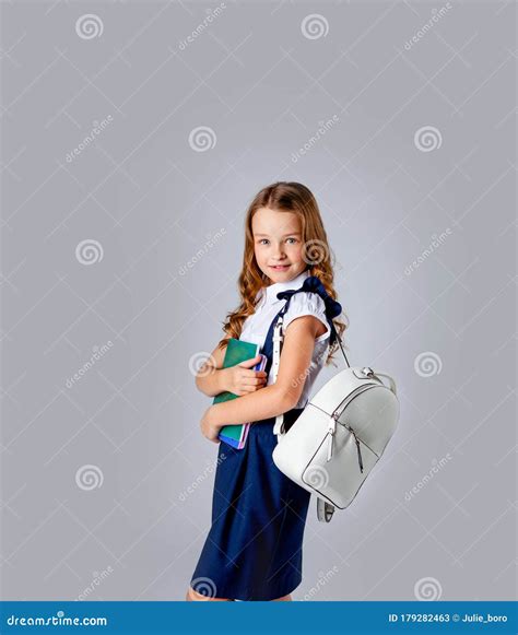 Una Chica Linda Con El Uniforme De La Escuela Lleva Los Cuadernos De La Escuela En Las Manos