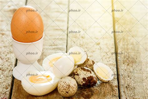 عکس تخم مرغ و تخم بلدرچین آب پز در پس زمینه چوبی عکس با کیفیت و