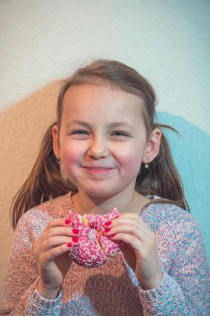 Premium Photo Close Up Of Girl Eating Donut At Home