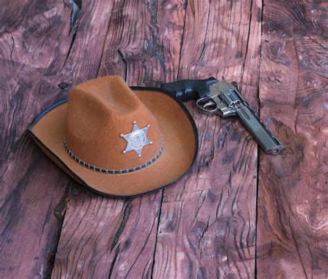 Premium Photo Sheriff Hat And Revolver On Wooden Background