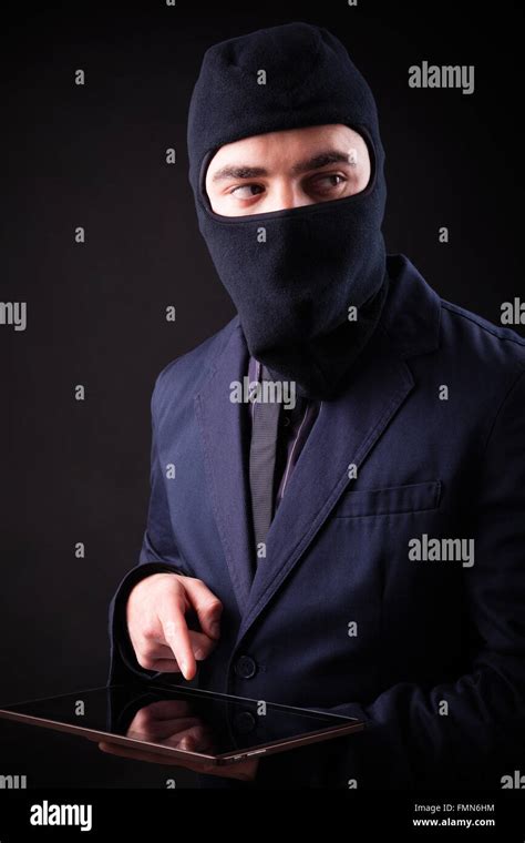 closeup portrait of a hacker stealing data from digital tablet stock