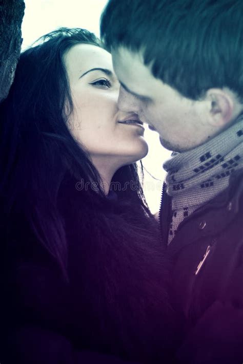 Het Aantrekkelijke Jonge Paar Kussen Stock Foto Image Of Sneeuw Selectief