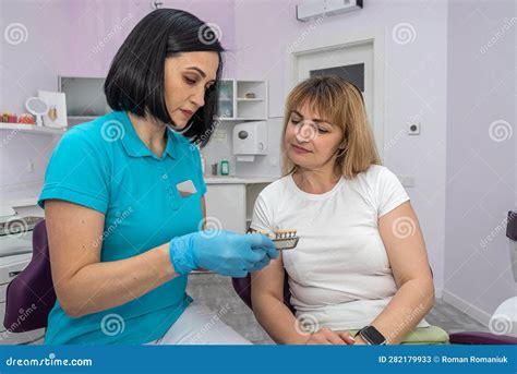 The Dentist Selects The Tone Of The Patient S White Teeth With A Pallet