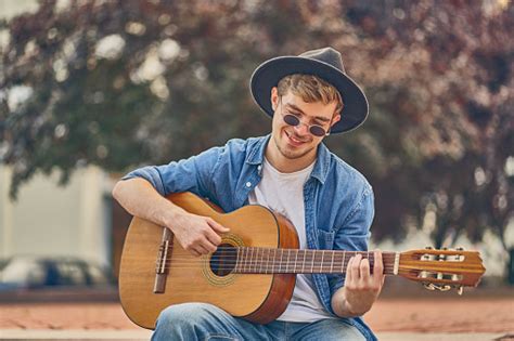 기타를 연주하는 청년 모자를 가진 세련된 힙스터 남자는 음악과 휴일을 즐긴다 기타 현악기에 대한 스톡 사진 및 기타 이미지 기타 현악기 남자 놀기 Istock