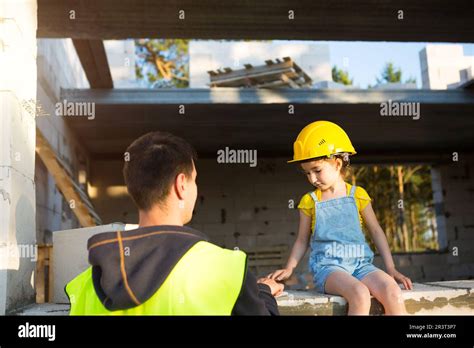 Dad And Daughter Are At Construction Site Of Their Future Home The